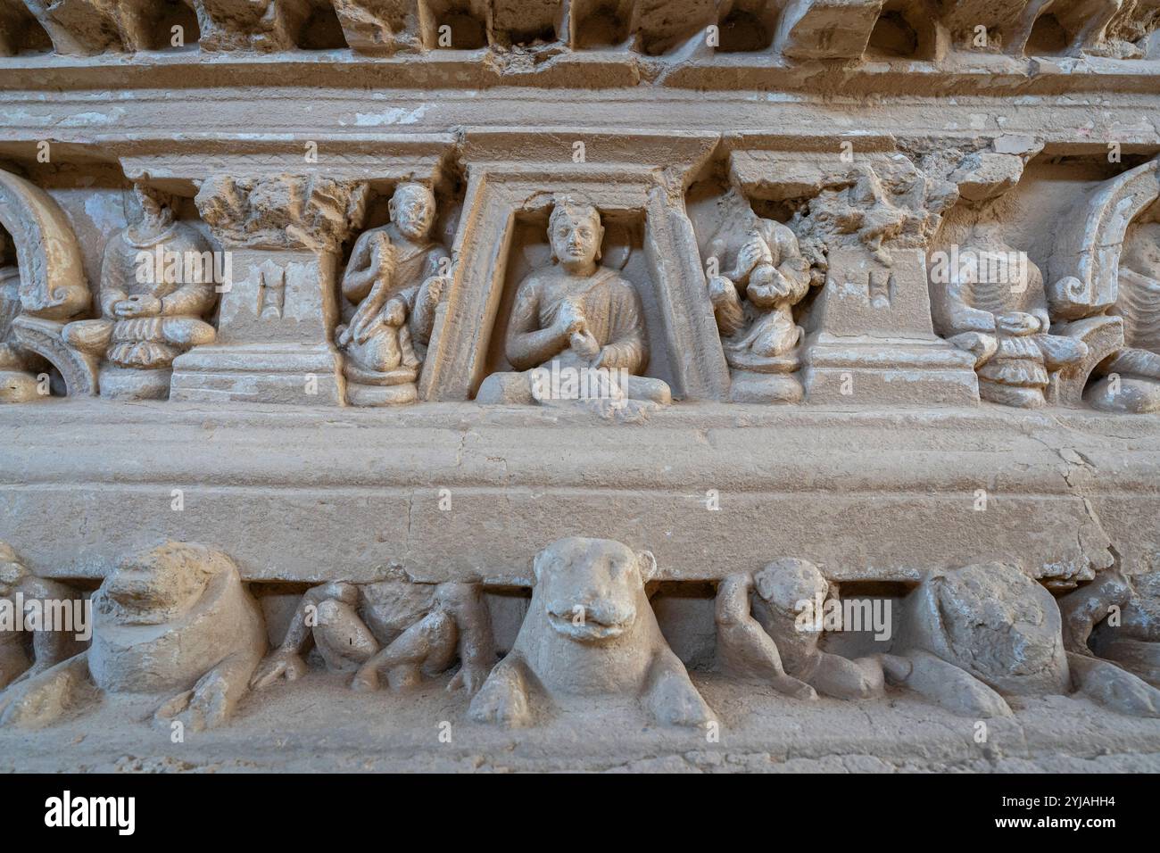 Closeup view of ancient votive stupa base with sitting Buddha and lions ...
