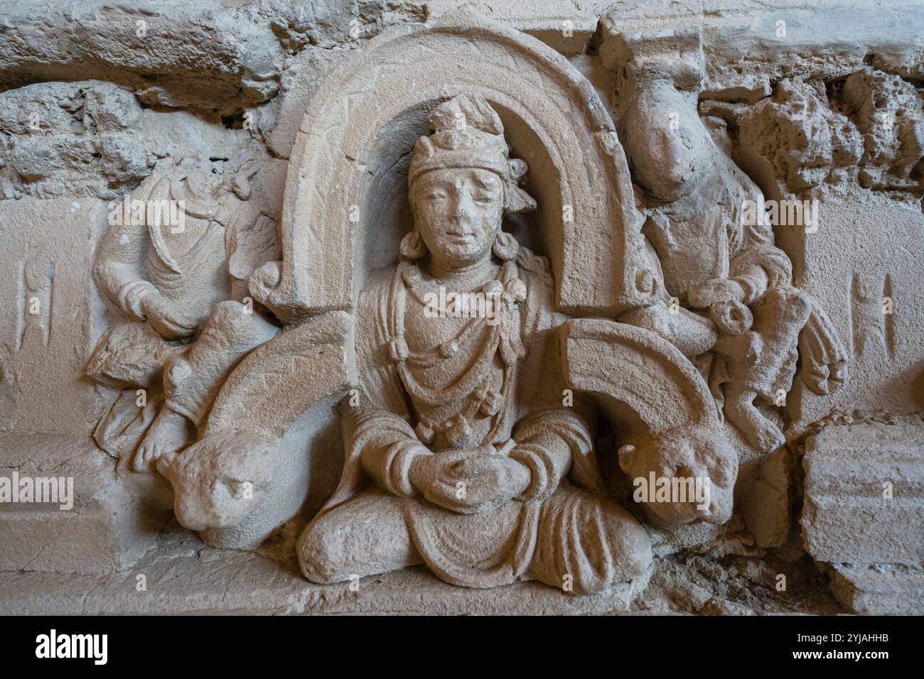 Closeup detail view of ancient stone carving with sitting Buddha and ...