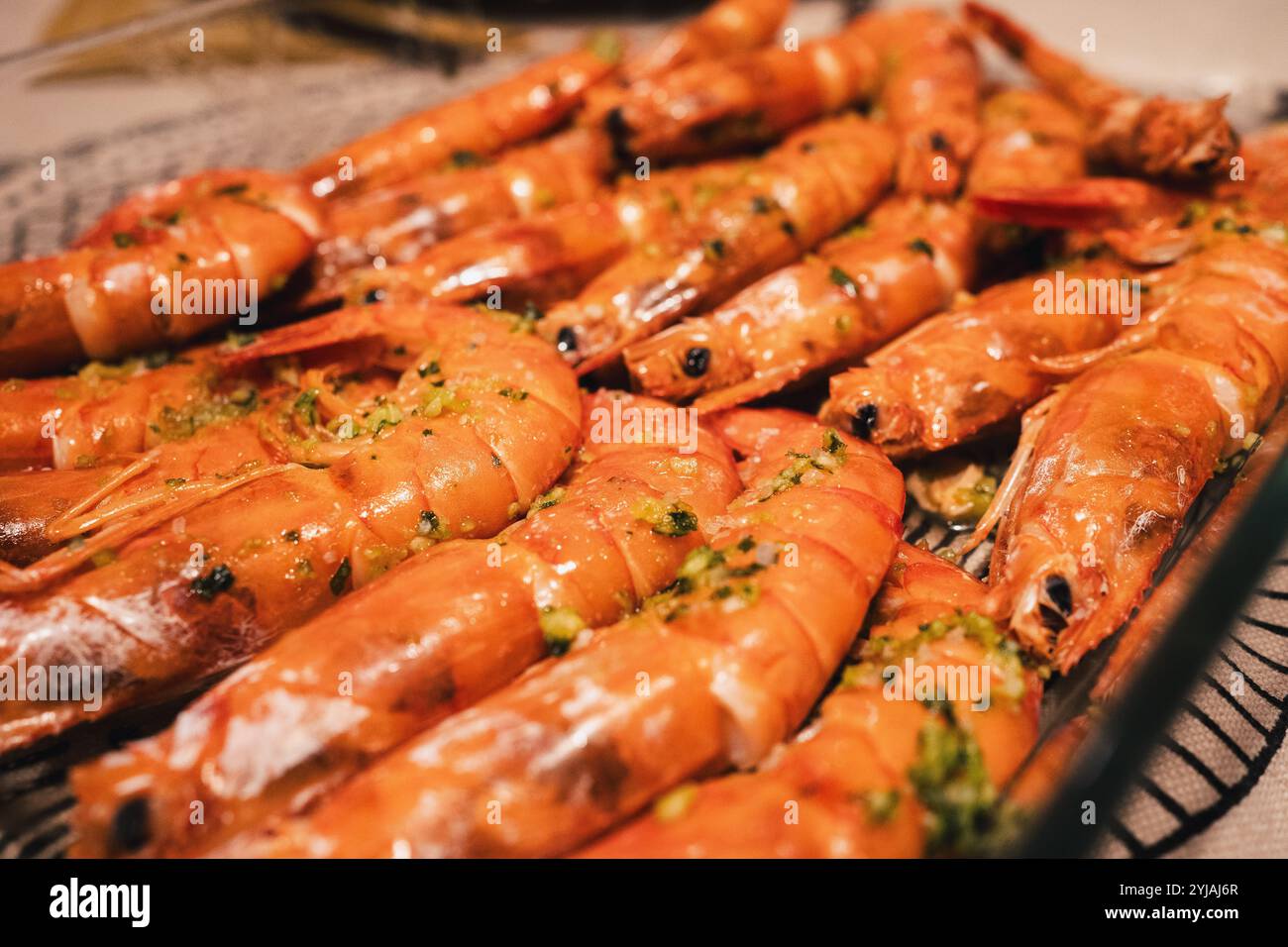 A plate of shrimp with a green sauce. The shrimp are cooked and are ...