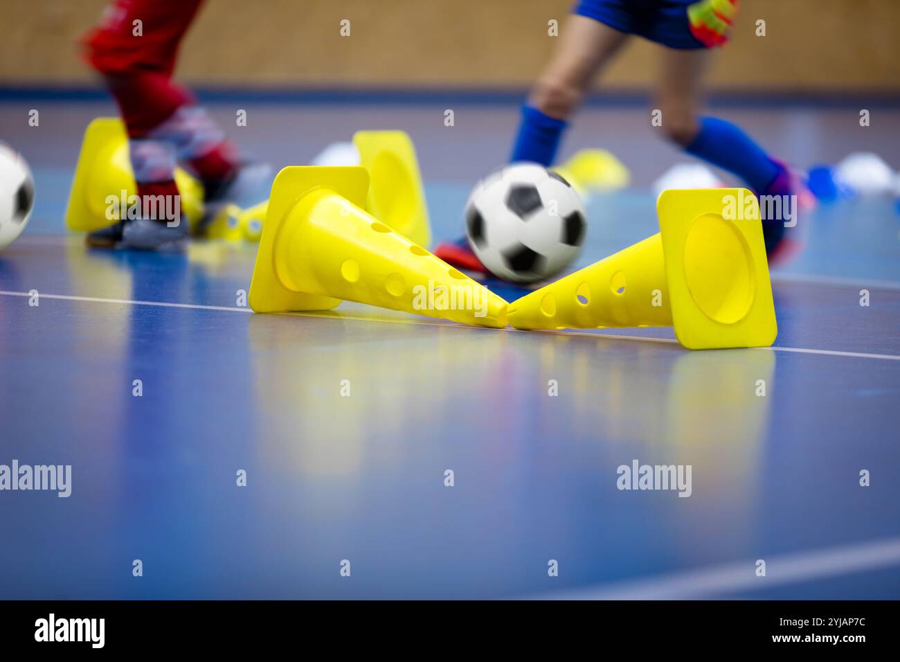 Indoor soccer young player with a soccer ball in a sports hall ...