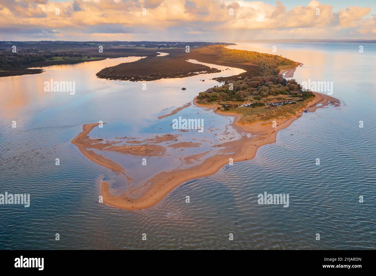Aerial view of dawn over a sand bar at the end of coastal peninsula at ...