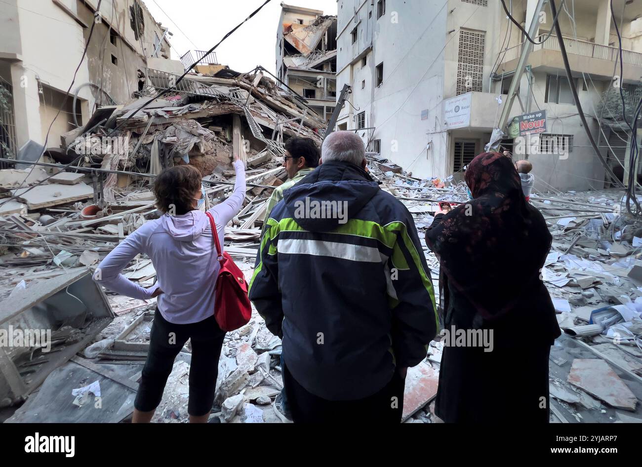 Residents check their destroyed building hit in an Israeli airstrike in ...