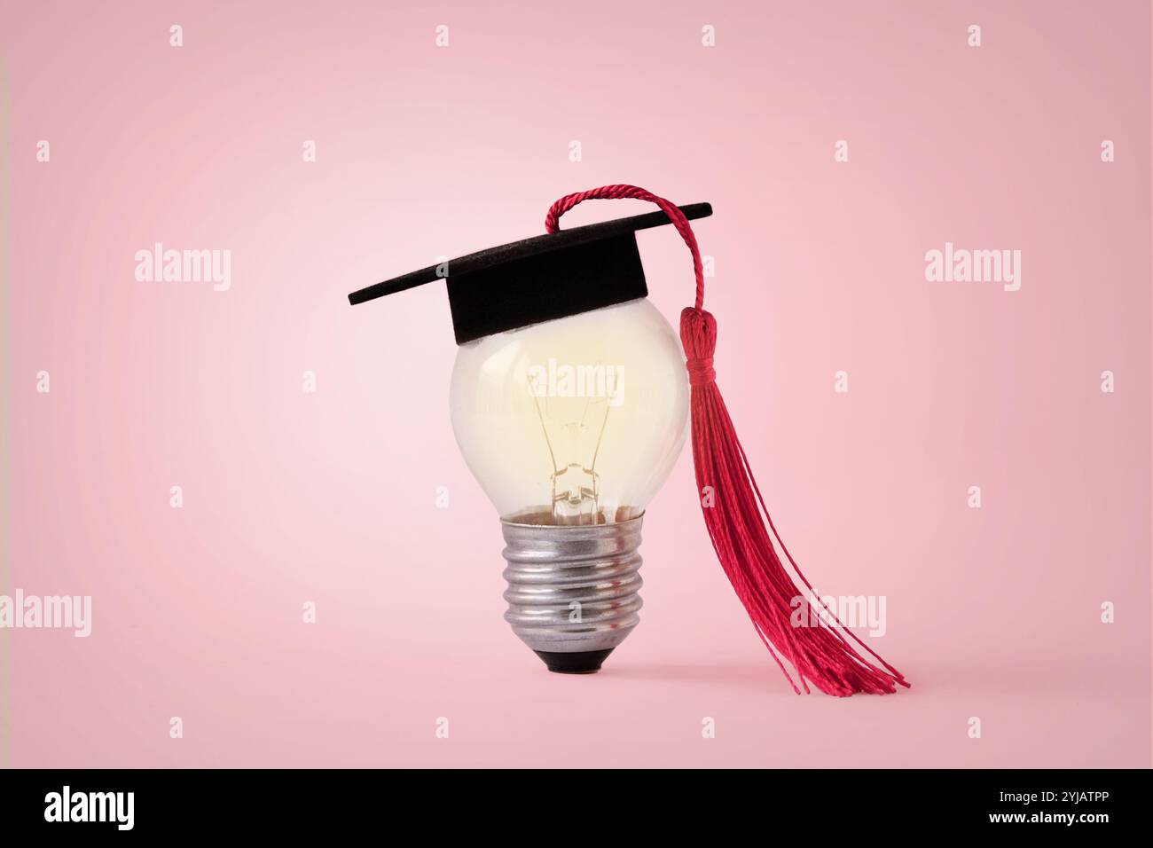 Light bulb with graduation hat on pink background - Concept of women ...