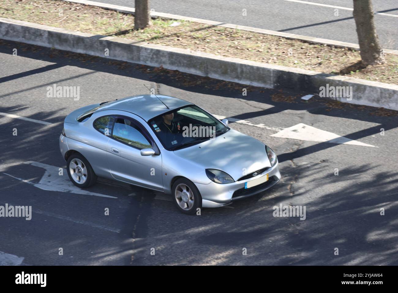 Silver ford puma is being driven down a city road by a man Stock Photo ...