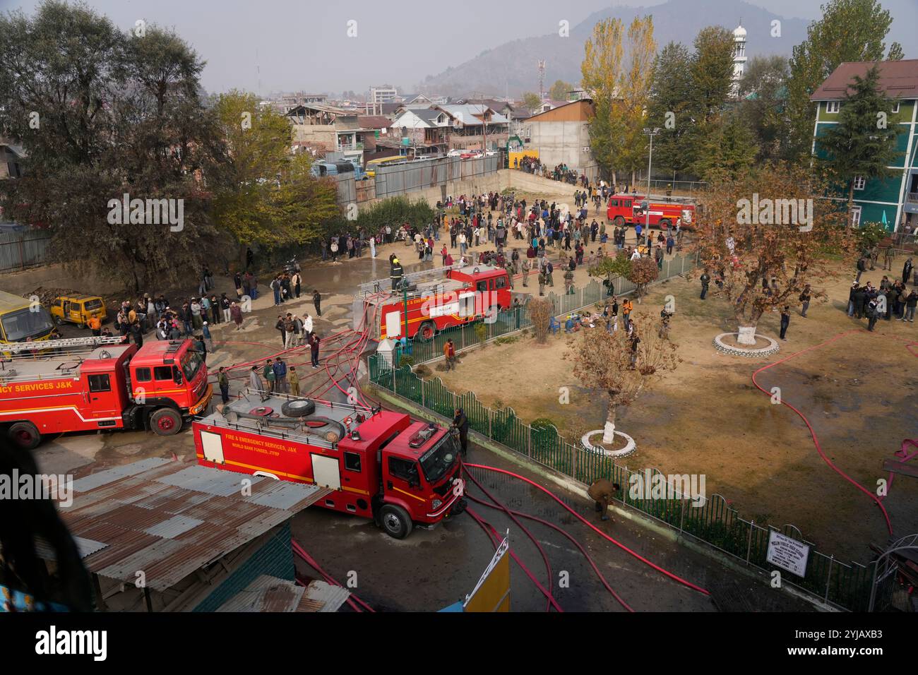 Indian firefighter vehicles are parked near a school building as they ...