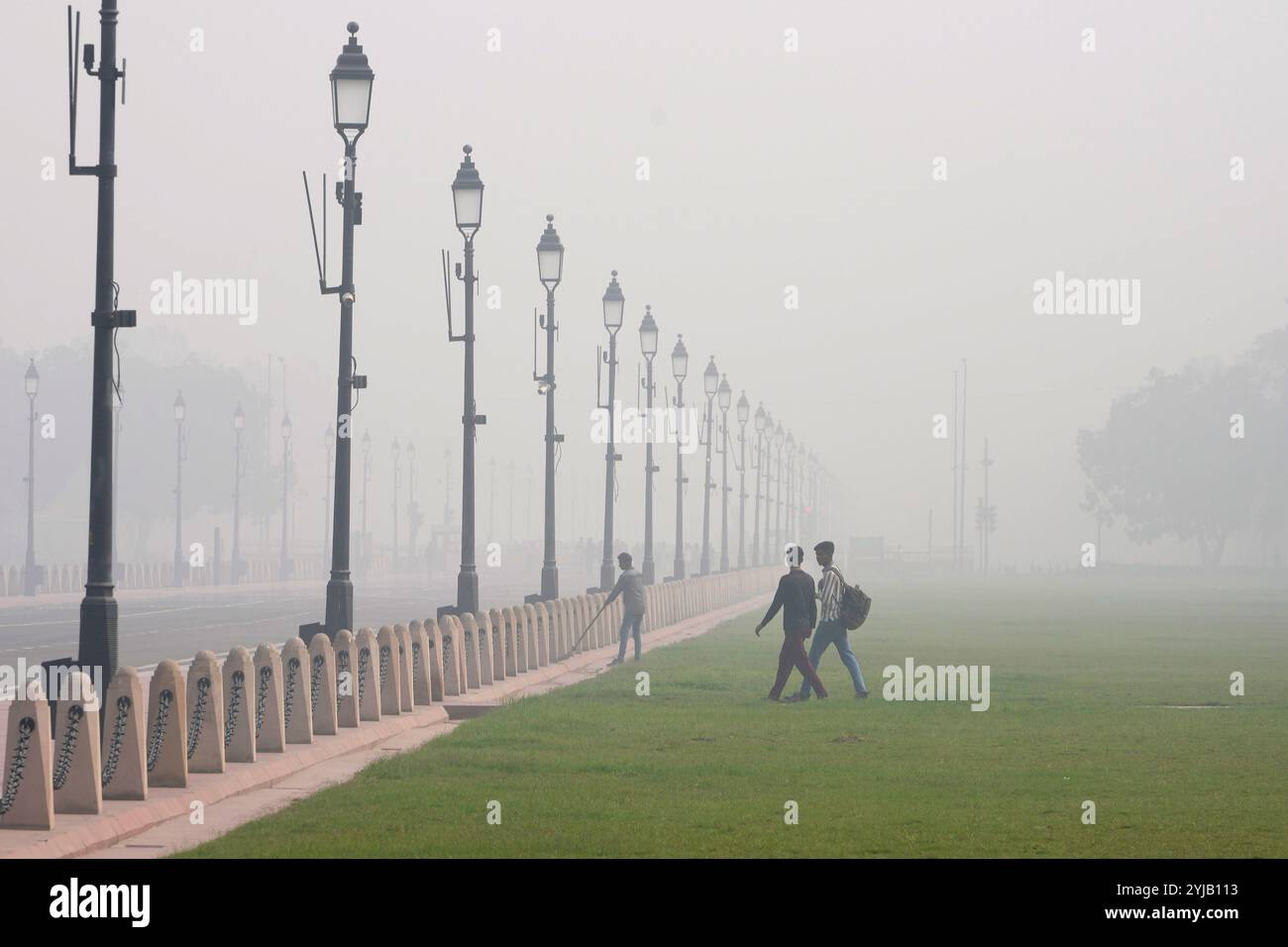 A worker sweeps a pathway surrounded by a thick layer of smog in New ...
