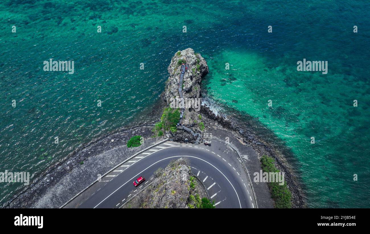 An aerial photo capturing a road winding alongside the majestic ocean ...