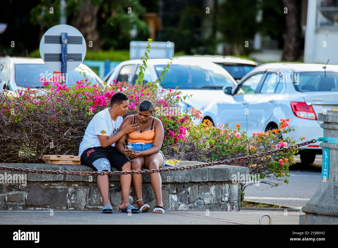 A man and a woman, both locals, sitting together on a bench in ...