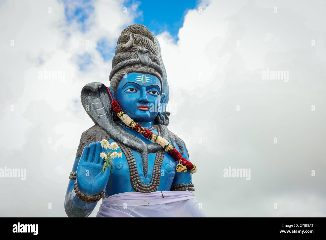 A statue of a Hindu deity in Mauritius holding a symbol of goodness and ...