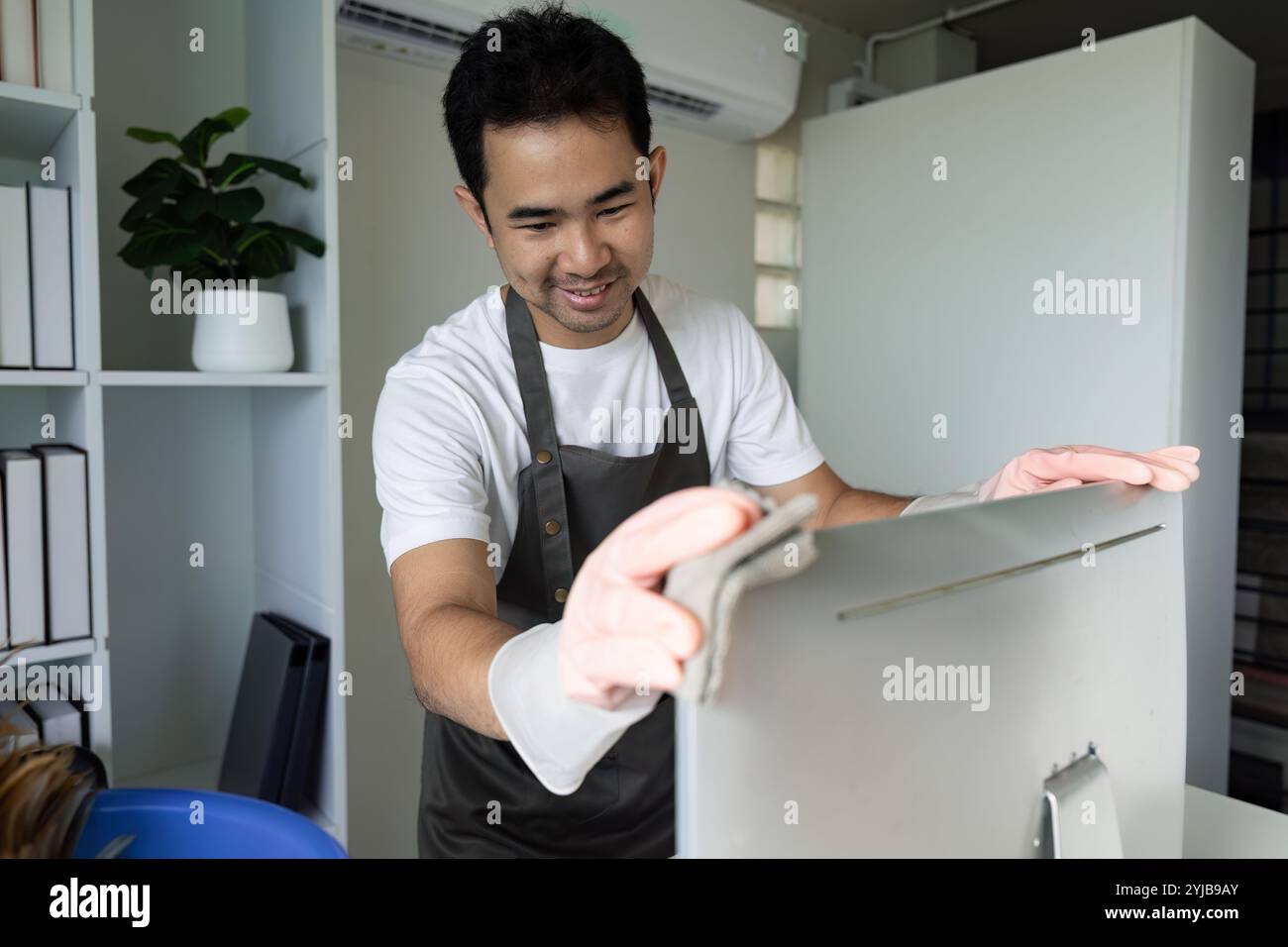 Smiling Man Cleaning Computer Monitor in Modern Office with Gloves and ...