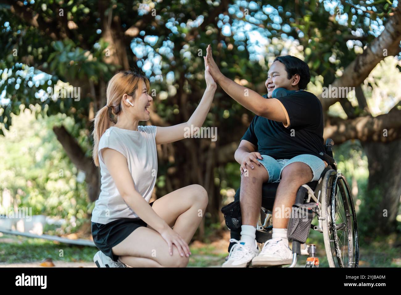 Joyful Interaction Between Friends Outdoors, One in a Wheelchair ...