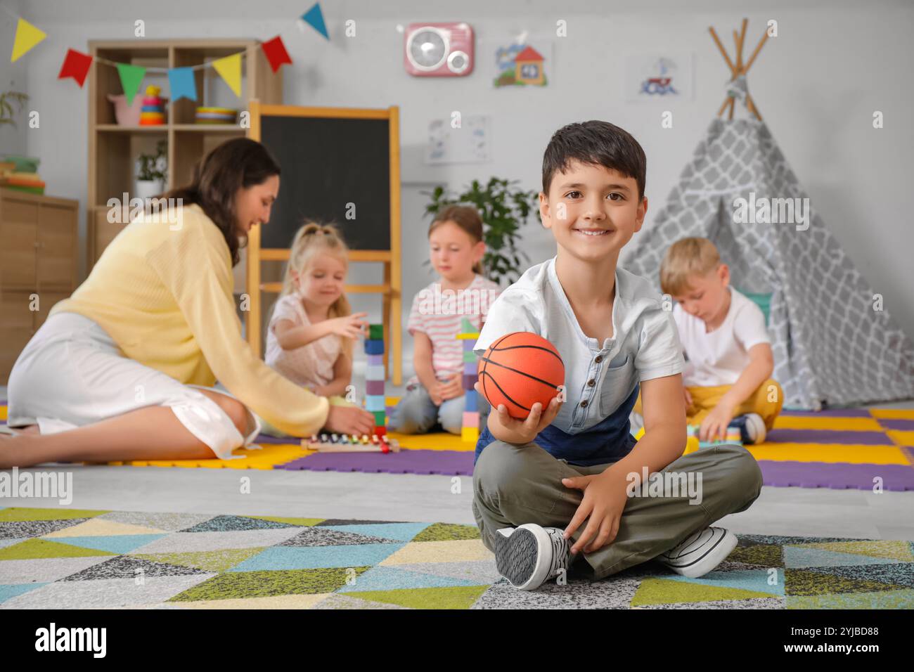 Little boy playing with ball in kindergarten Stock Photo - Alamy