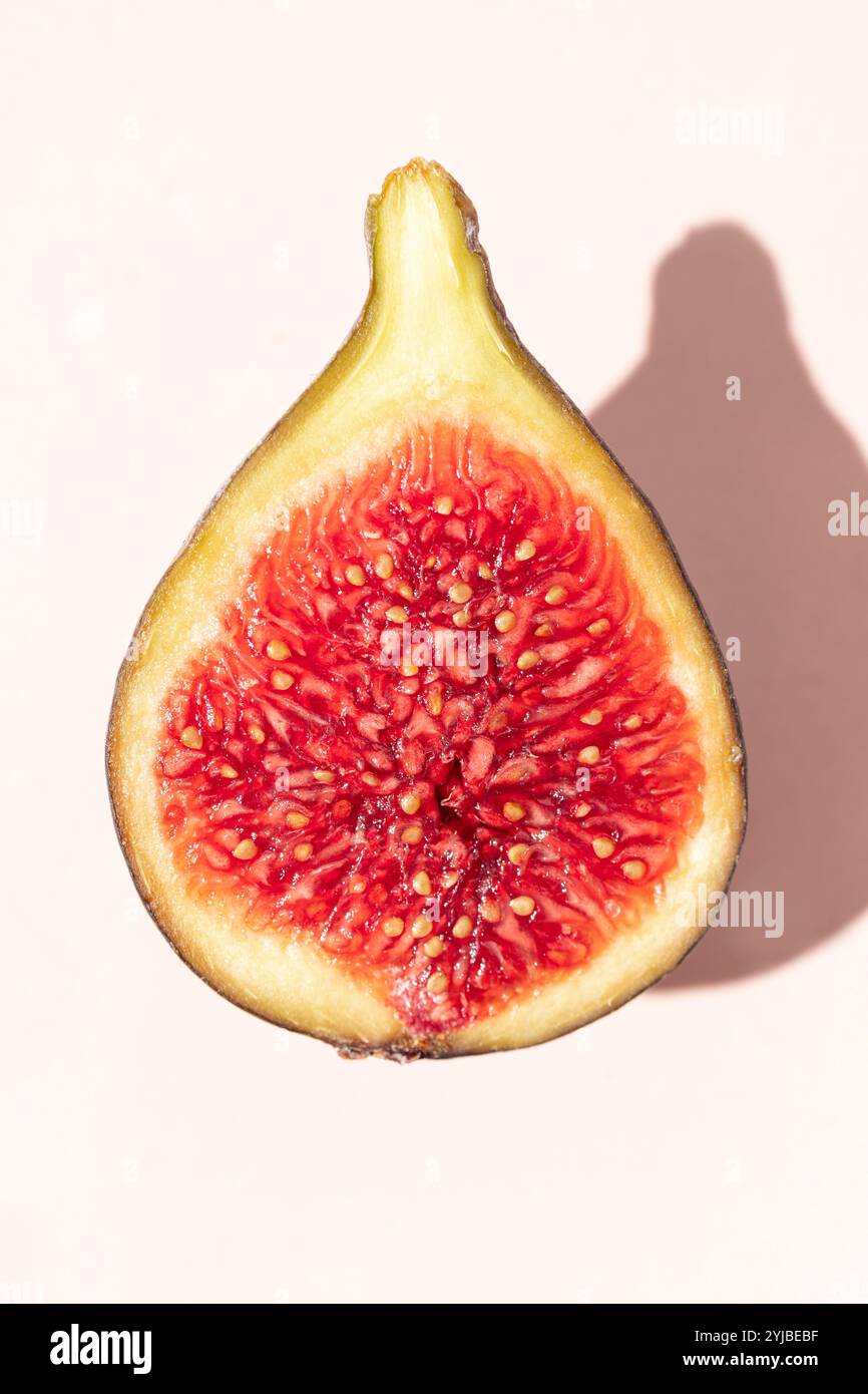 A detailed close-up of a fresh fig sliced in half, revealing its ...