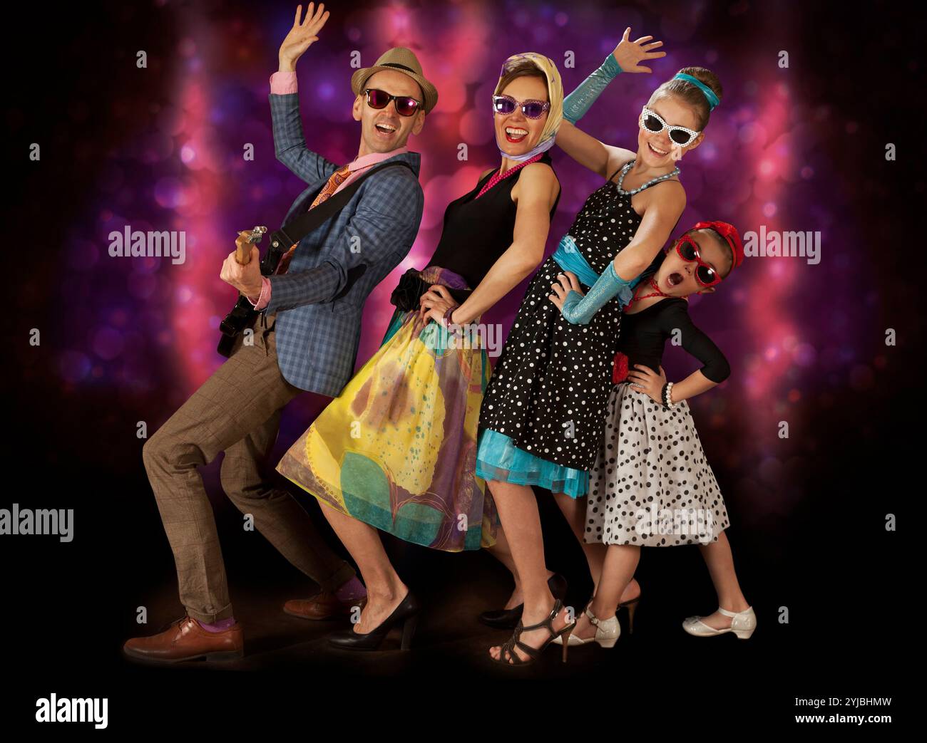 Rockabilly family band having fun posing with guitar and dancing in ...