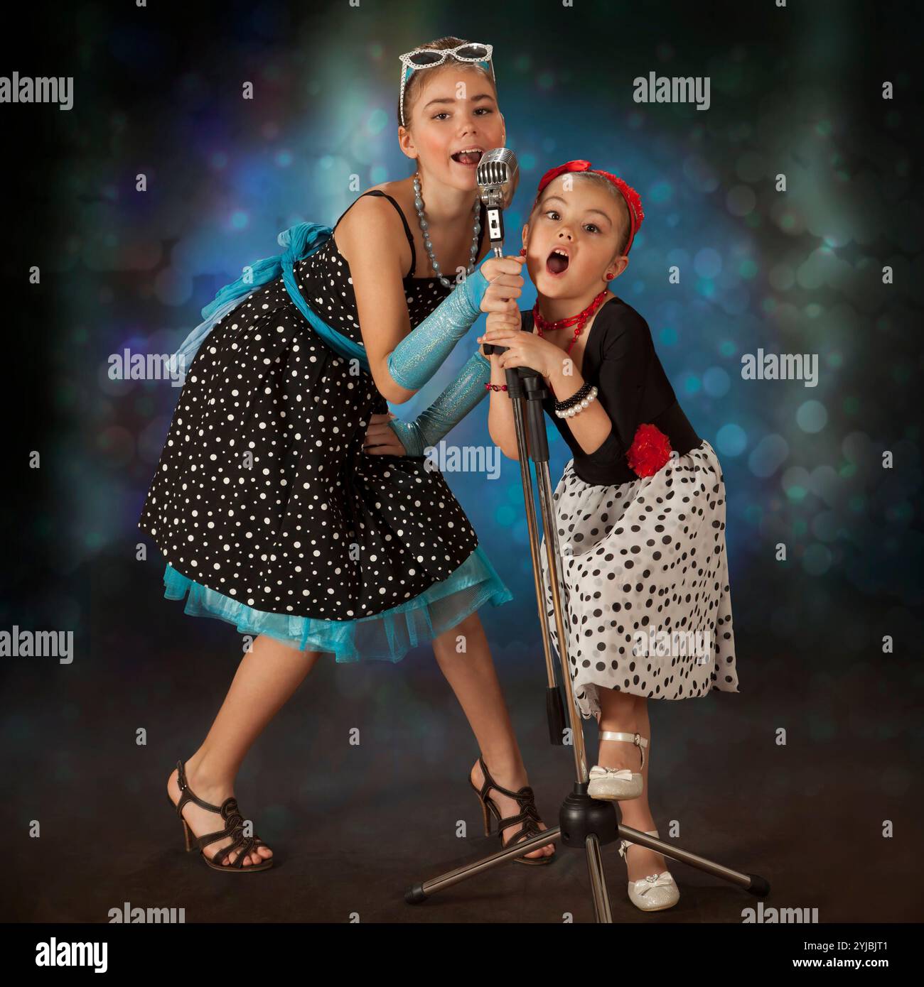 Rockabilly girls singing and posing with vintage microphone in 1950’s ...