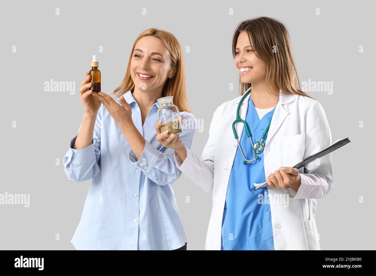 Female homeopathic doctor and mature woman with remedy on light ...