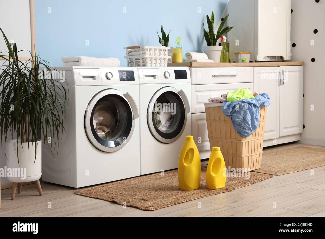 Interior of laundry room with washing machines, counters and basket ...