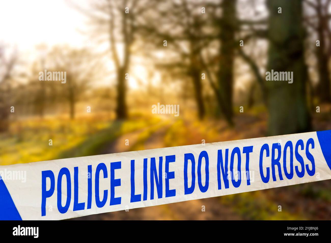 Blue and white police line do not cross crime scene tape in focus with ...