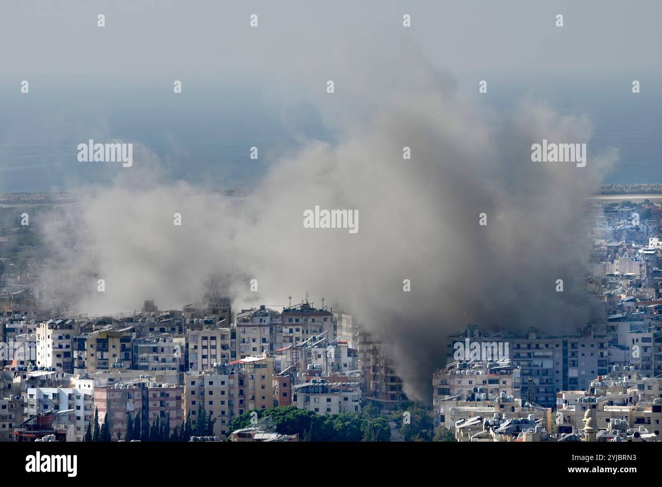 Smoke rises between buildings hit in an Israeli airstrike in Dahiyeh ...