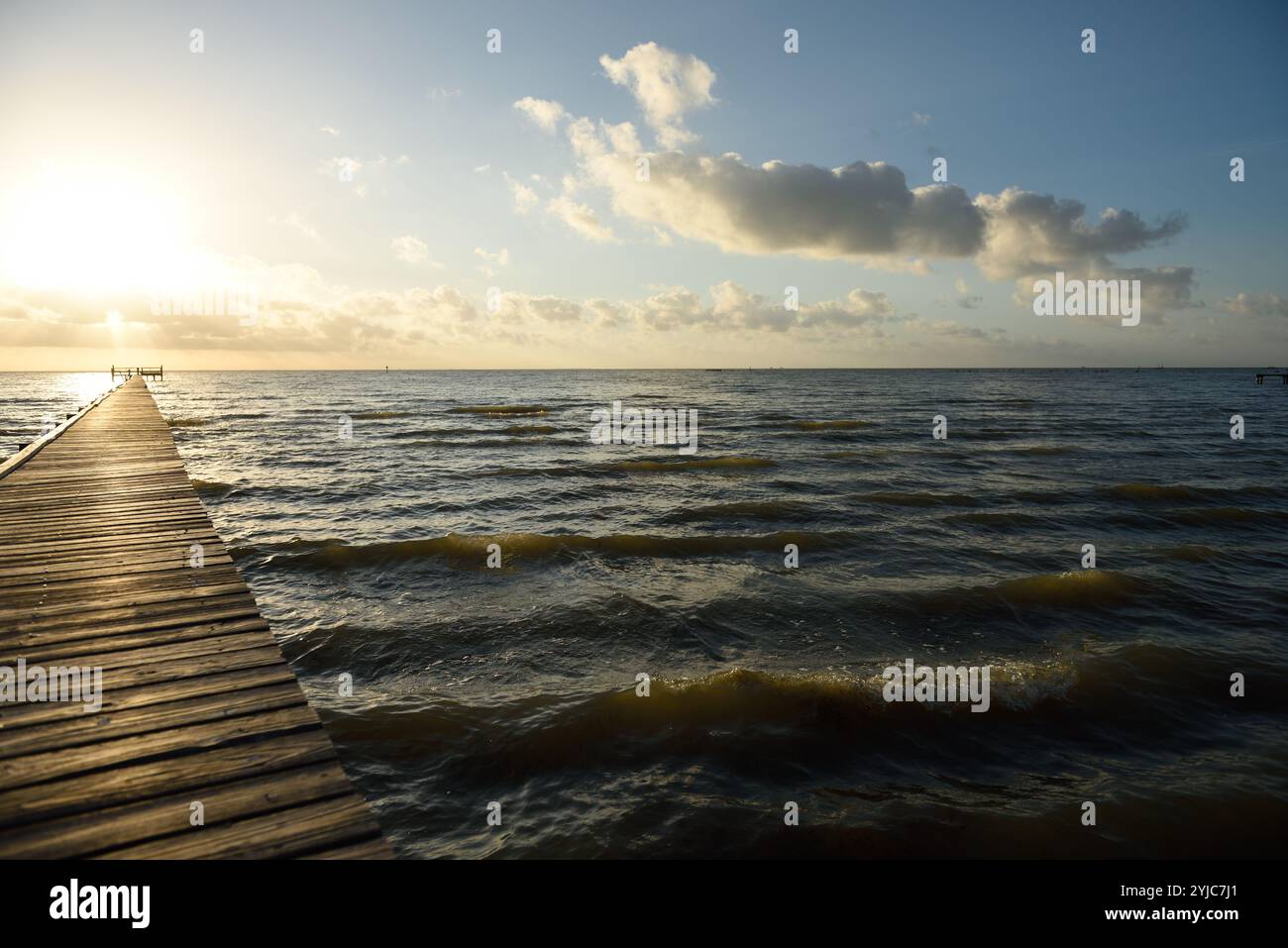 Wooden pier sunrise with blue sky and white clouds, Gulf of Mexico in ...