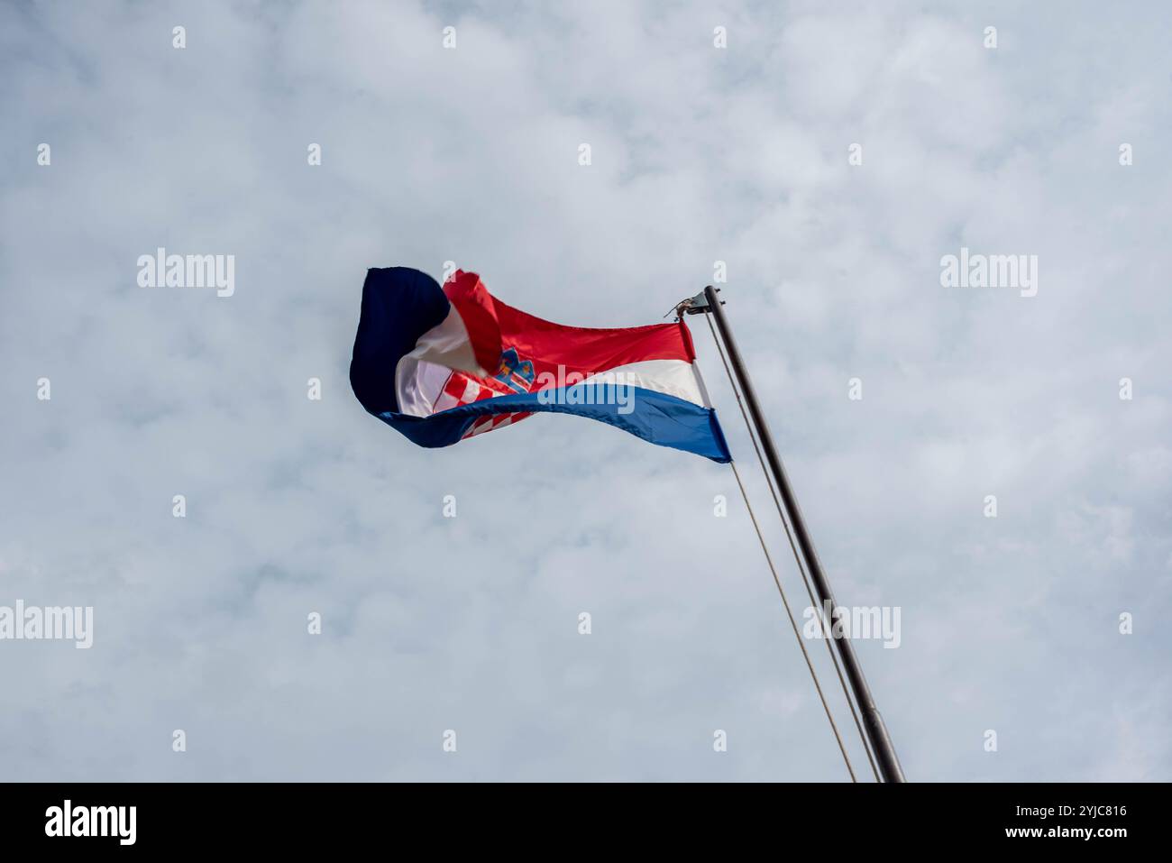 Croatian flag waving in the wind against a bright blue sky, symbolizing ...