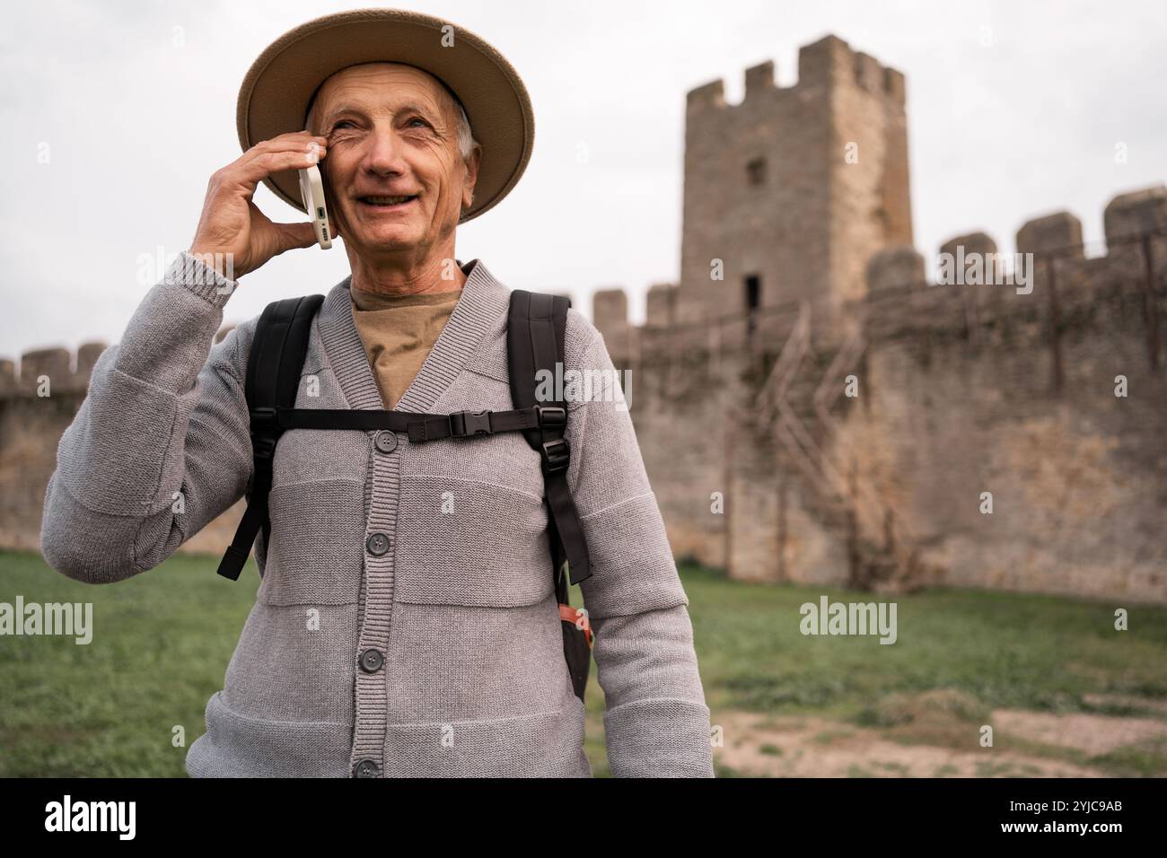 Portrait of retired tourist making phone call while standing against ...