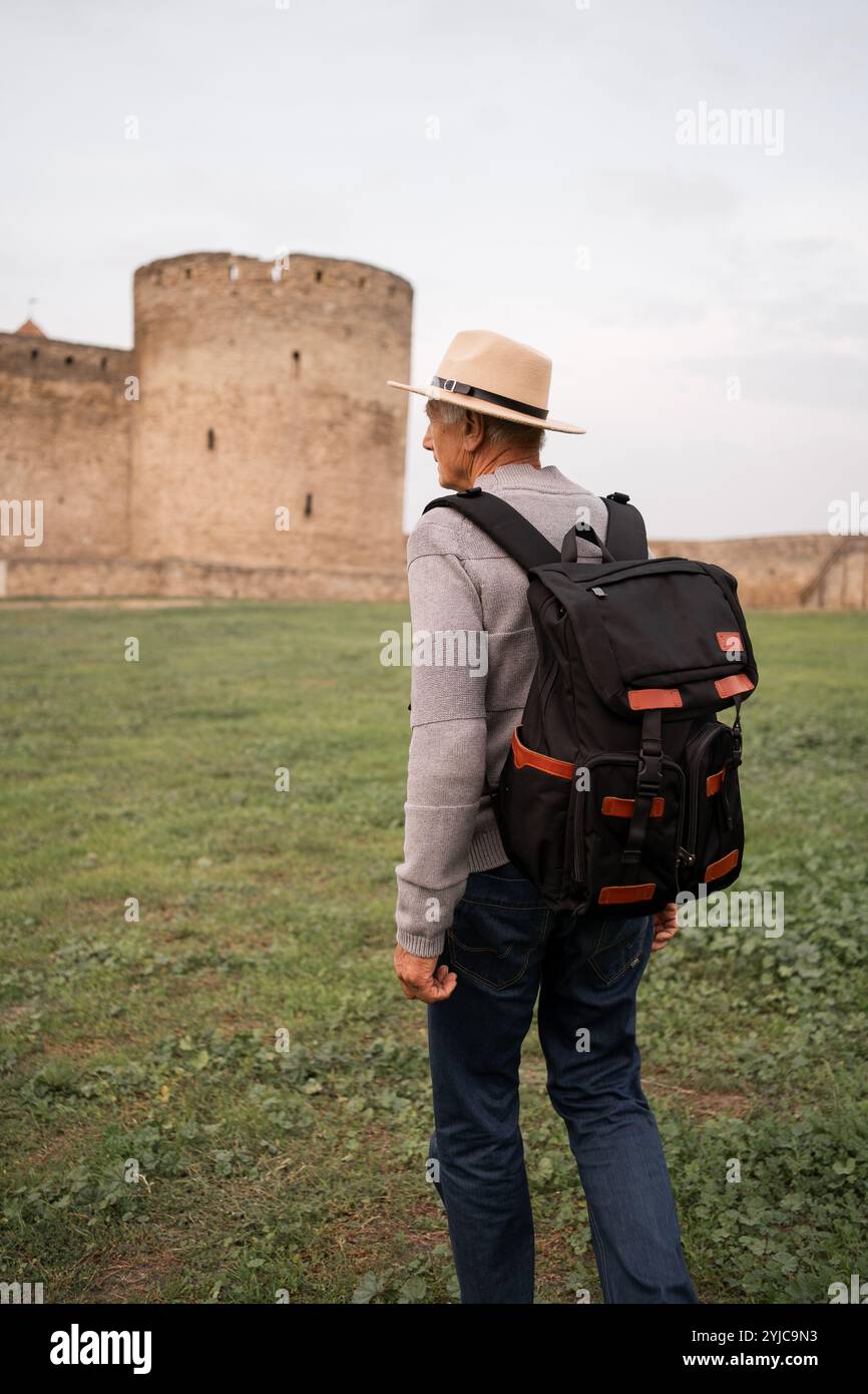 Retired man walking towards ancient stone fortress walls Stock Photo ...