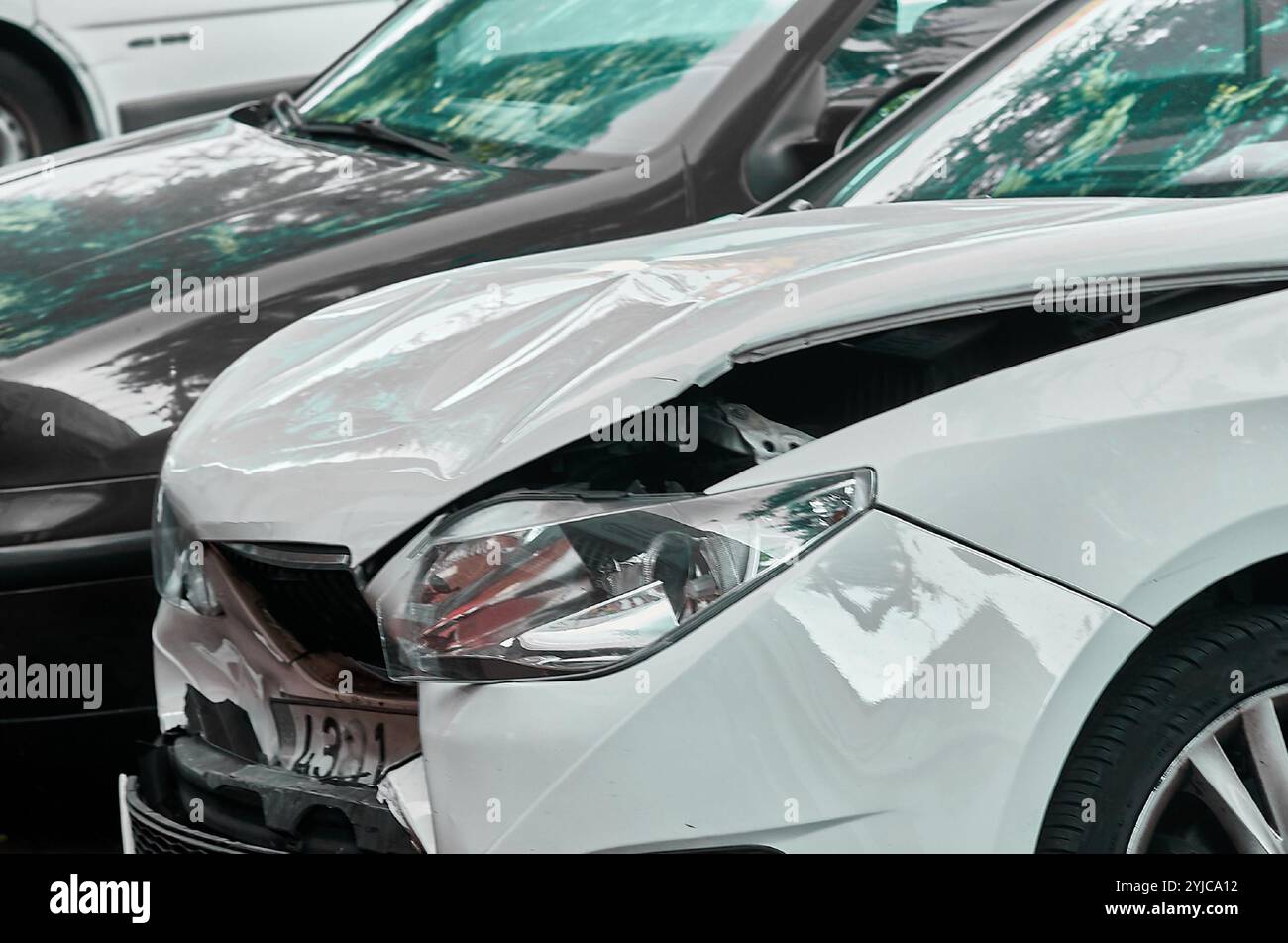 This image shows a severely damaged car with a completely crushed front ...