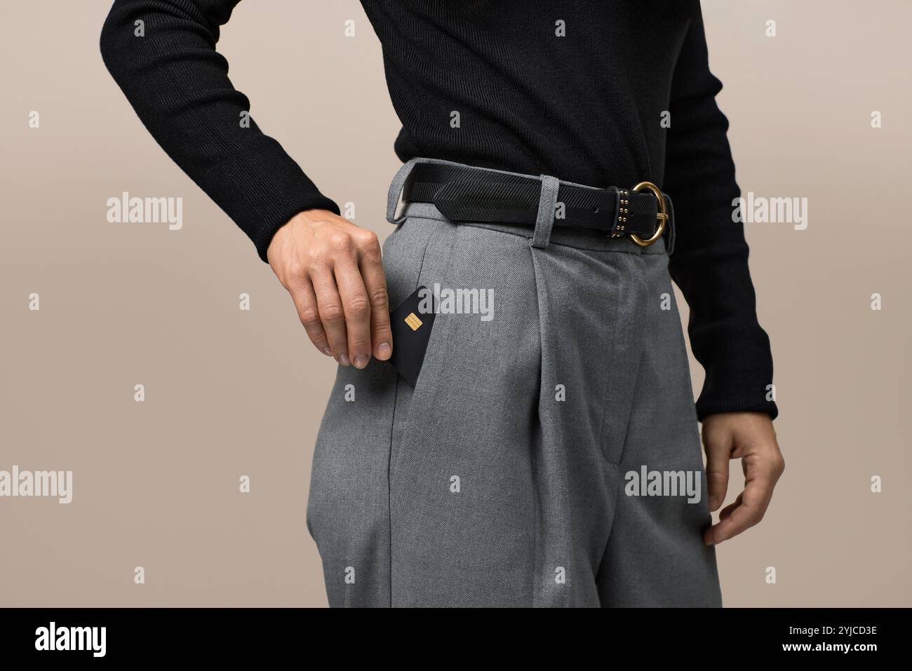 female hand putting black premium credit bank card in pants pocket ...