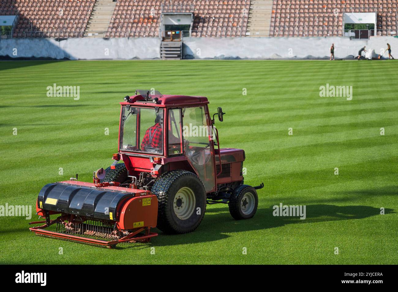 Man in tractor aerating a soccer field Stock Photo - Alamy