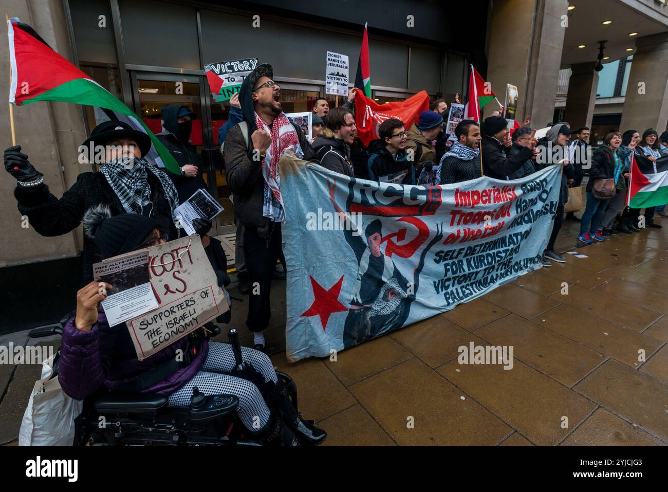London, UK. 31st March 2018. Protesters pose in front of Marks ...