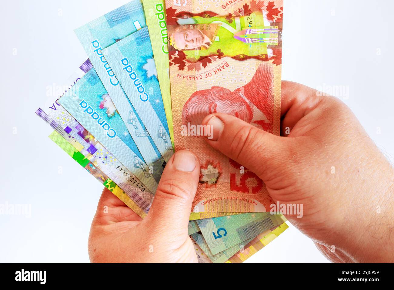 Hand holding counting Canadian money dollar cash banknotes bills in ...