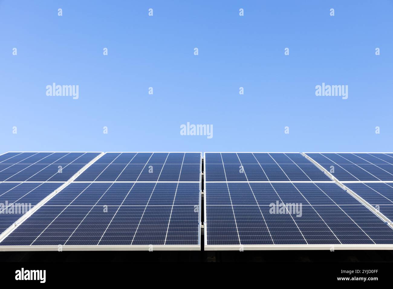 Aerial view of solar panel cells on clear blue sky background ...
