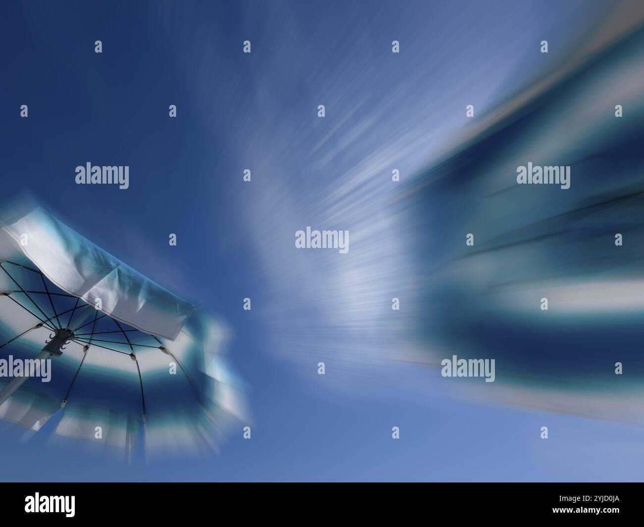 Parasols in front of a blue sky with clouds, zoom effect Stock Photo ...