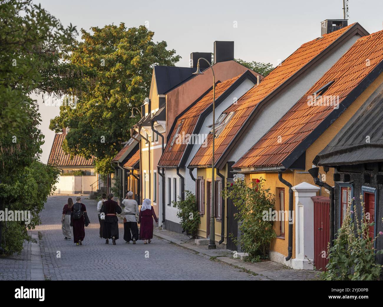 Visitors to the Medieval Week walk along a cobbled street in medieval ...
