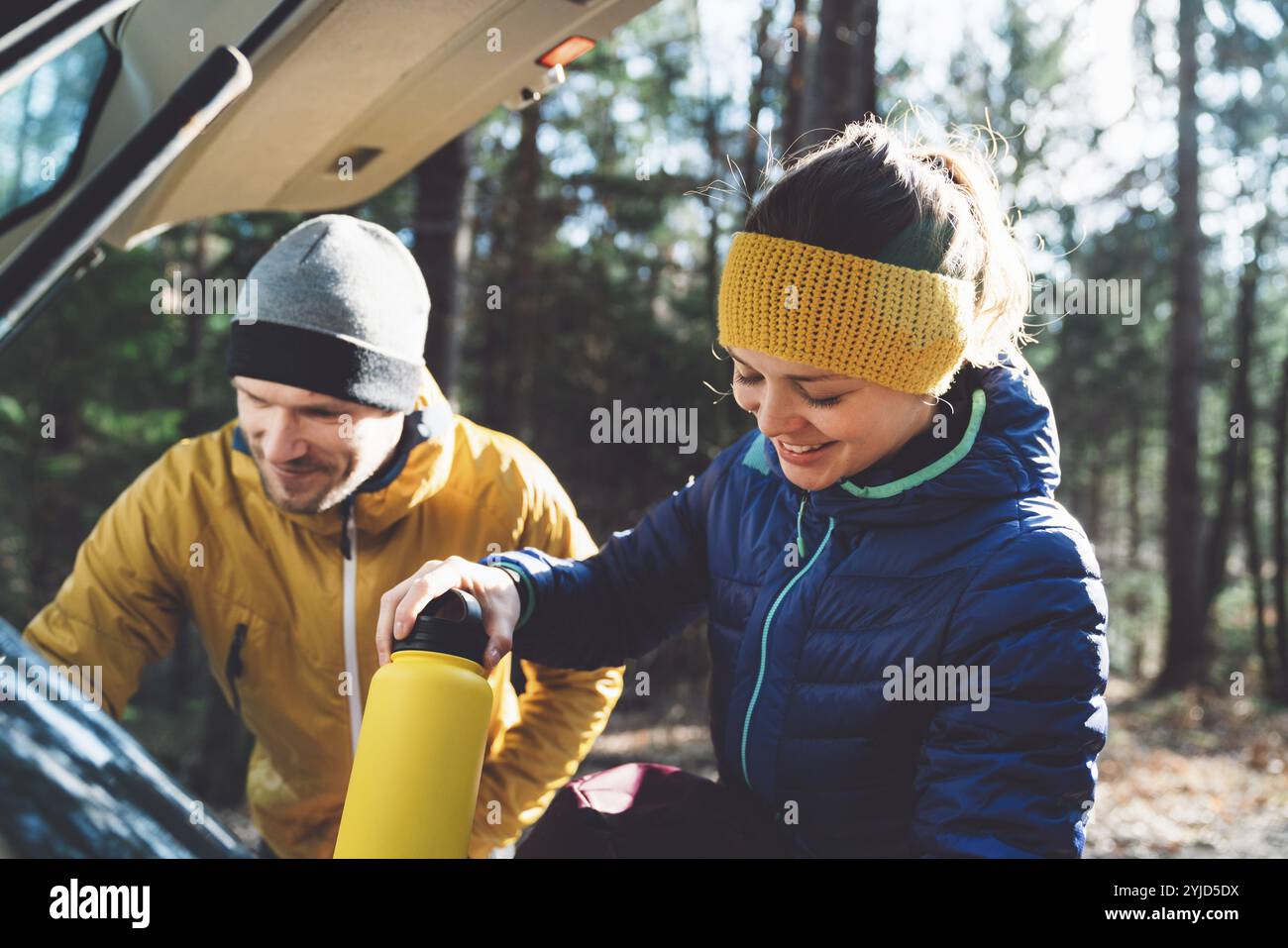 Hikers getting ready at the trunk of the car. Adventurous people ...
