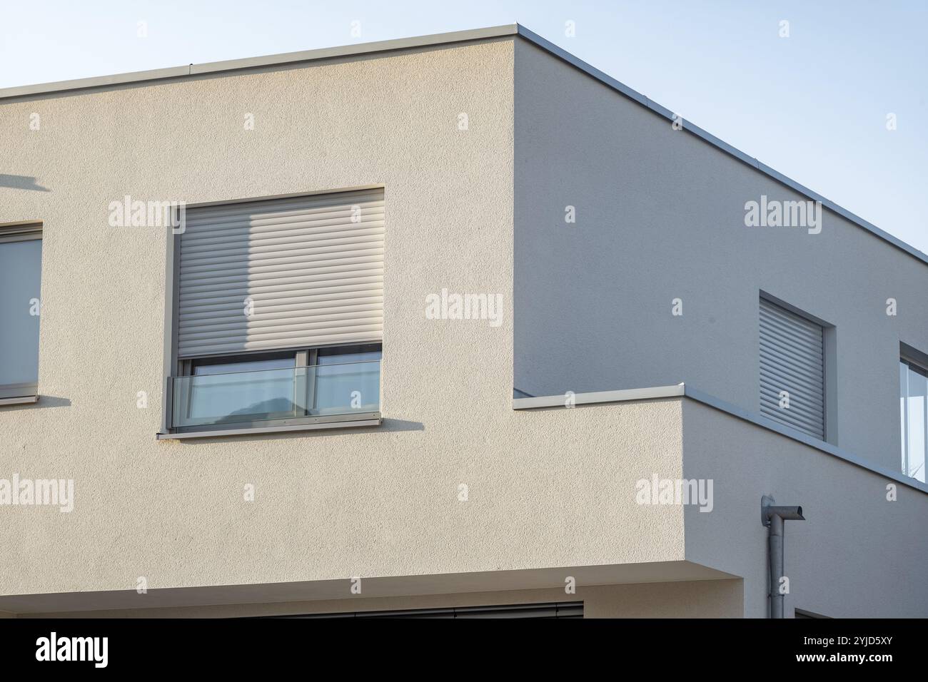 View of a modern house with windows and partially lowered shutters ...