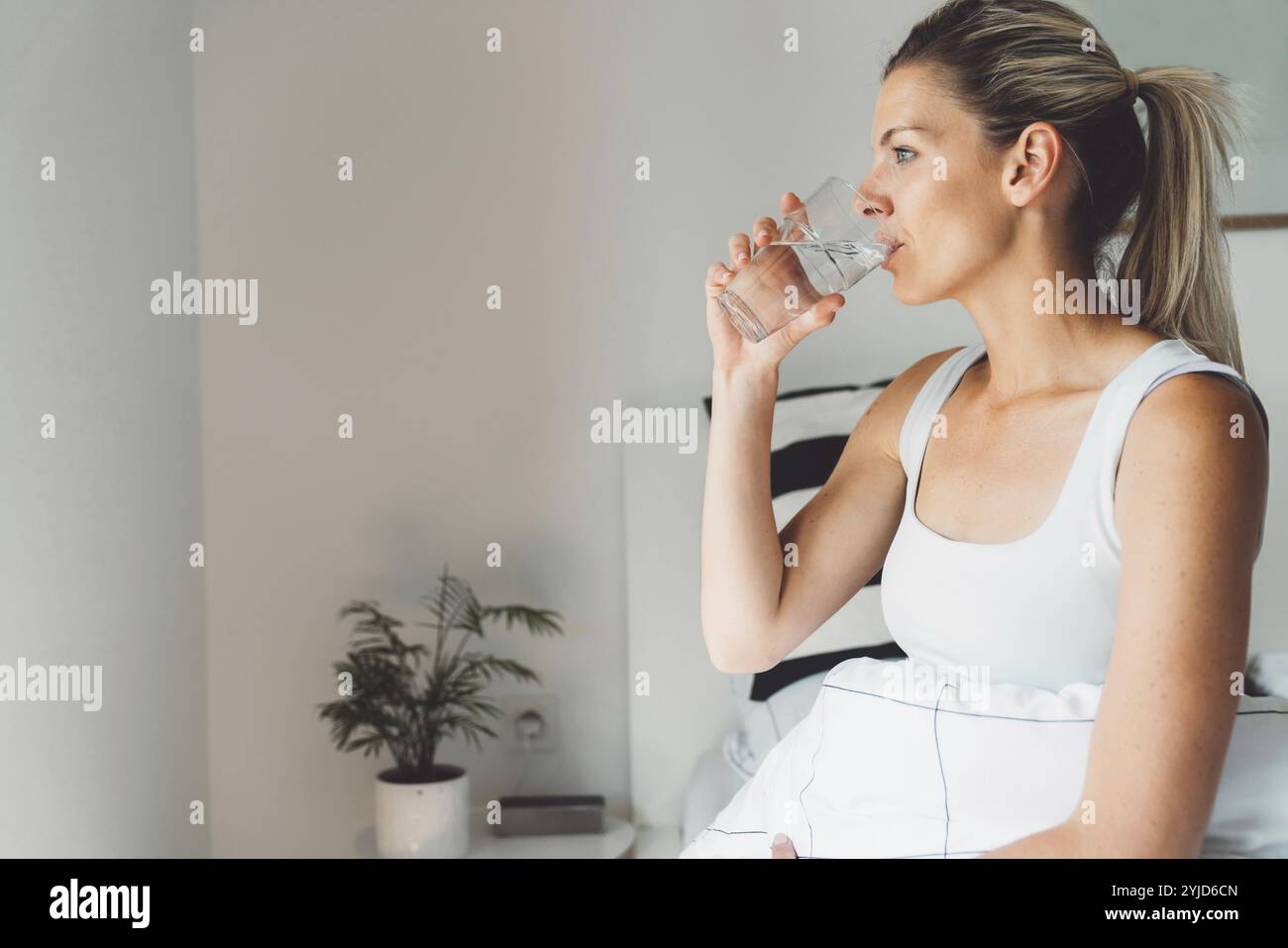 Smiling young caucasian woman taking her morning supplements, vitamin ...