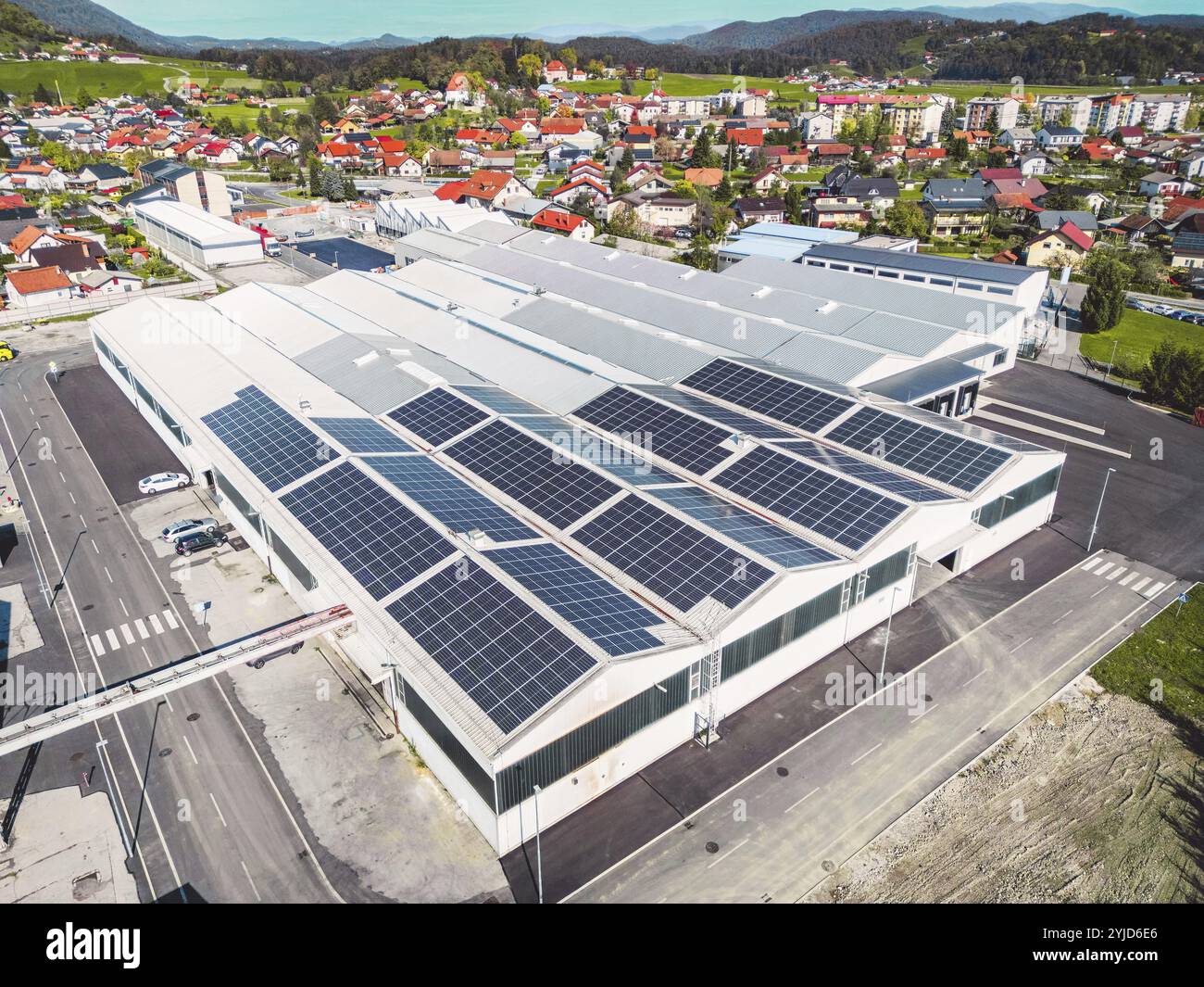 Aerial view of a factory in the suburbs with roof top covered with ...
