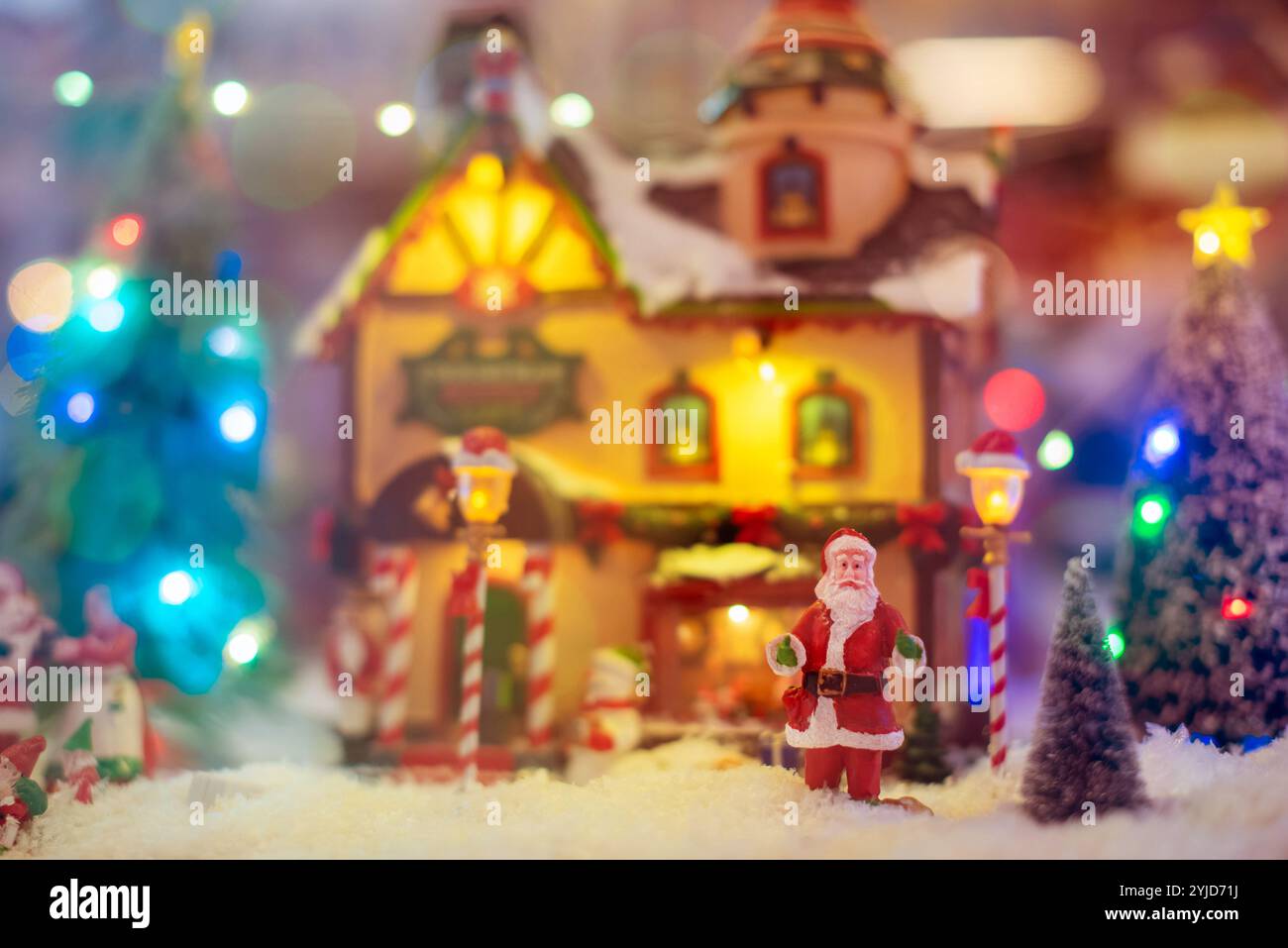 Miniature Santa Claus figurine standing in the snow in front of a ...