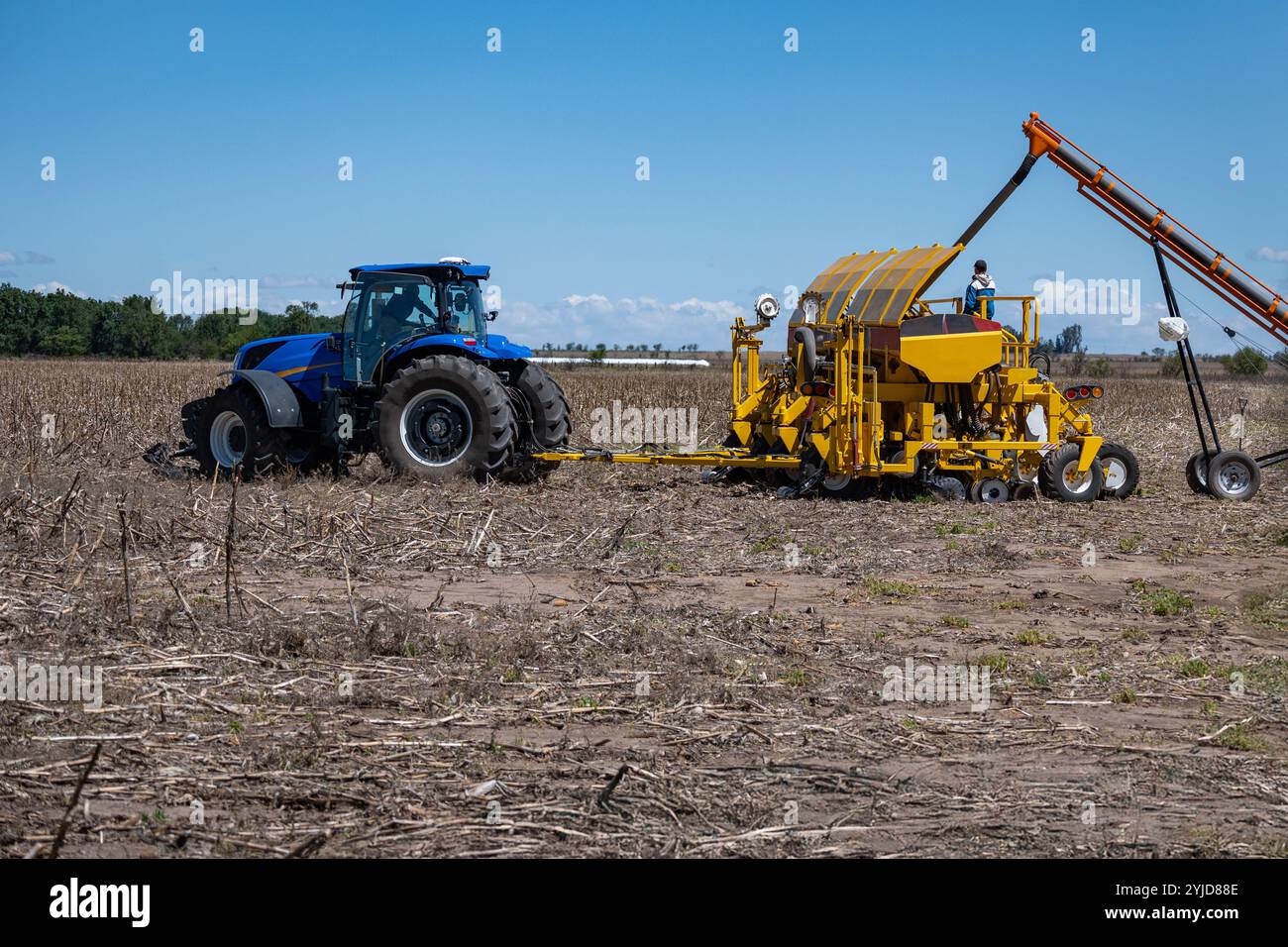 Loading seed into mechanical agricultural grain seeders. A tractor ...