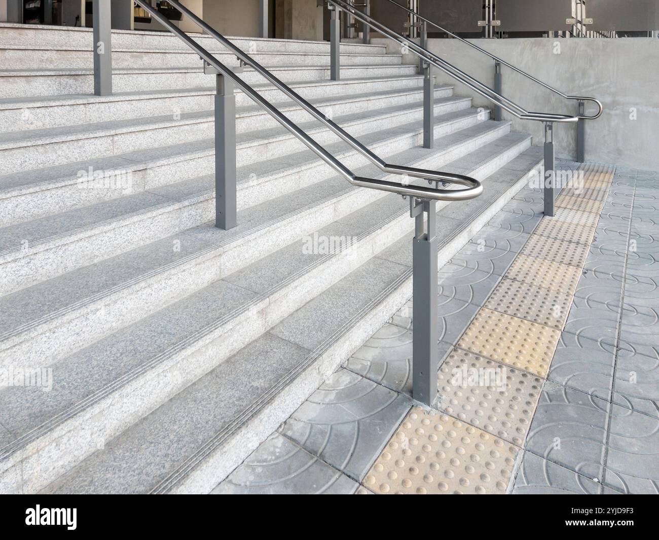 The concrete stairs with stainless steel handrails at the entrance to ...