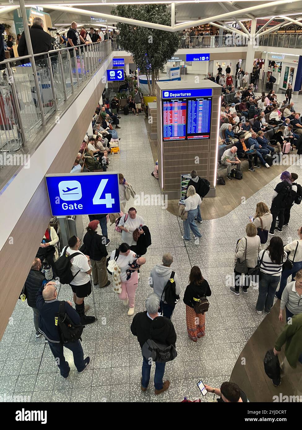crowded Bristol airport departure lounge with people waiting for their ...