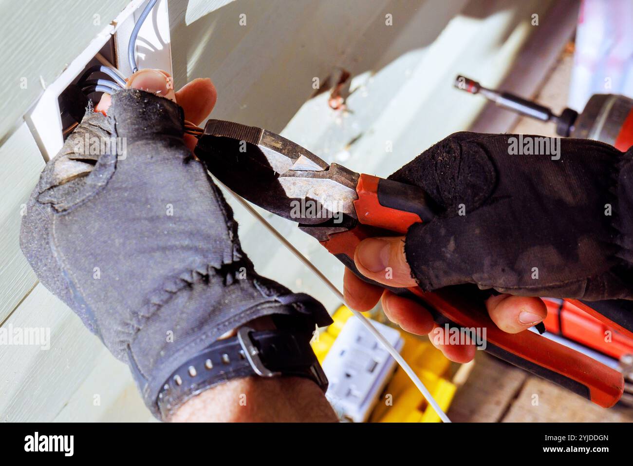 Electrician contractor connects installs electrical outlets on exterior ...