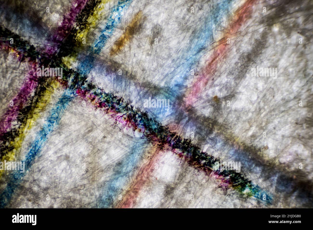 Coloured ink test lines on a newspaper, under a microscope at 4 times ...