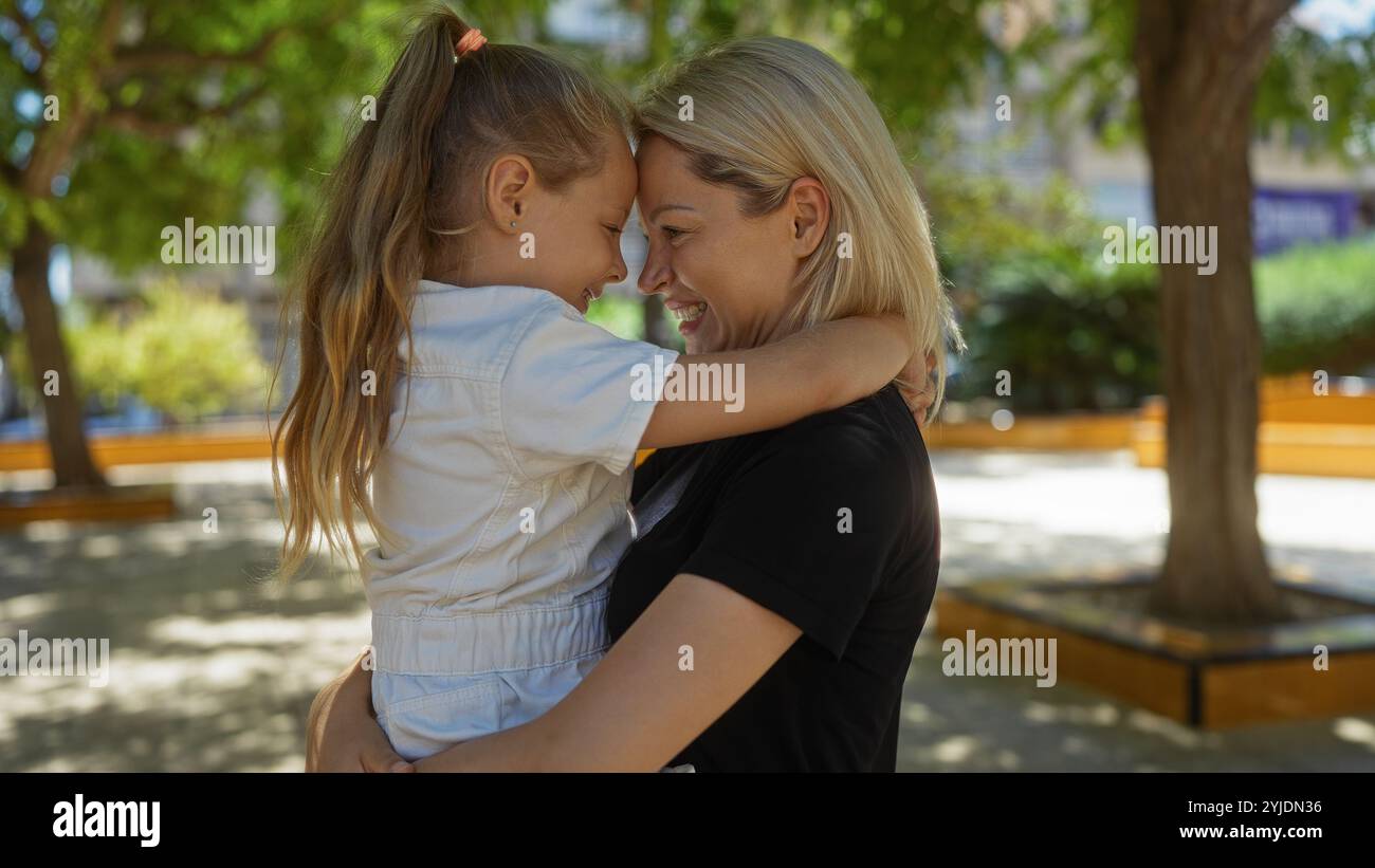 Woman and child embrace joyfully in an urban park, depicting a strong ...