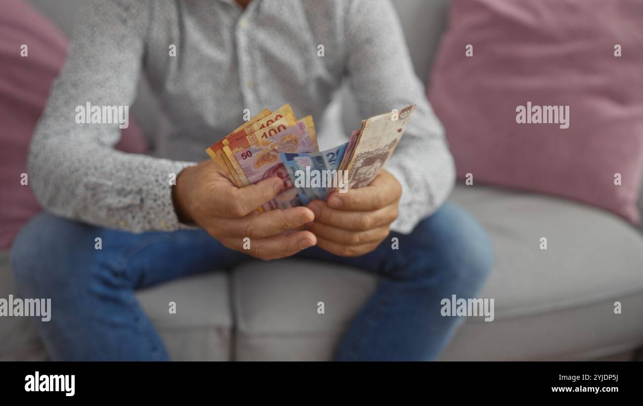Hispanic man counting mexican pesos indoors in a living room Stock ...