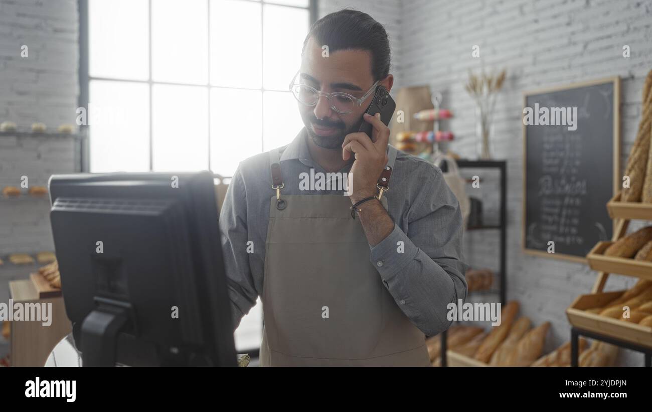 Young man with moustache in bakery shop talking on phone while wearing ...