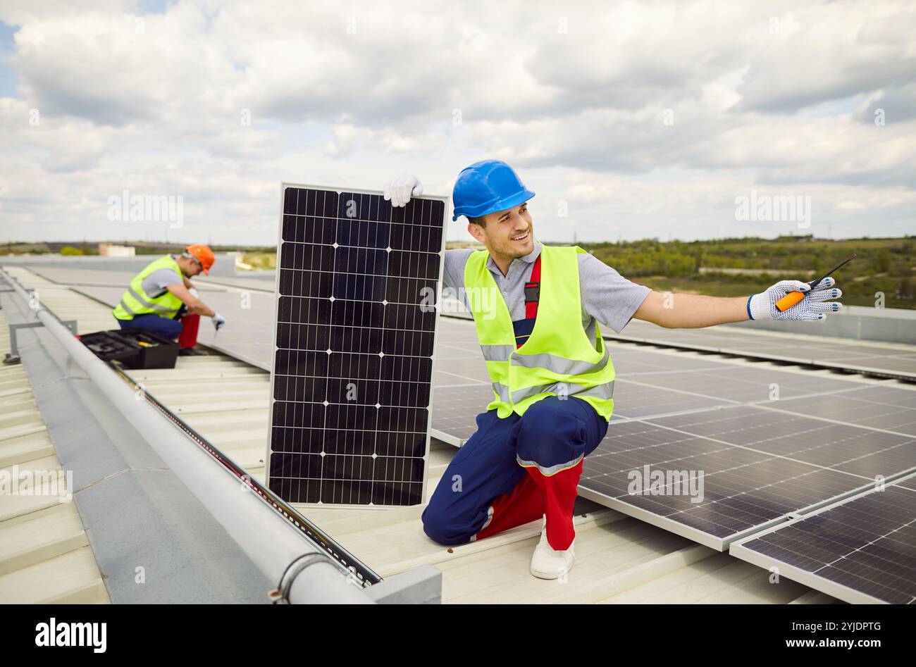 Electrical engineers in uniform installing photovoltaic solar panels on ...
