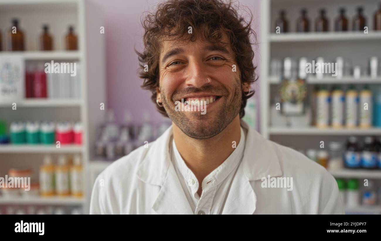 Young man smiling in a laboratory setting surrounded by pharmaceutical ...